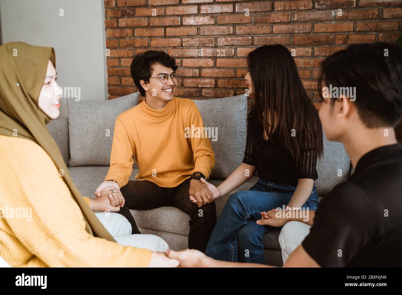 young couples face each other when holding hands with friends sitting ...