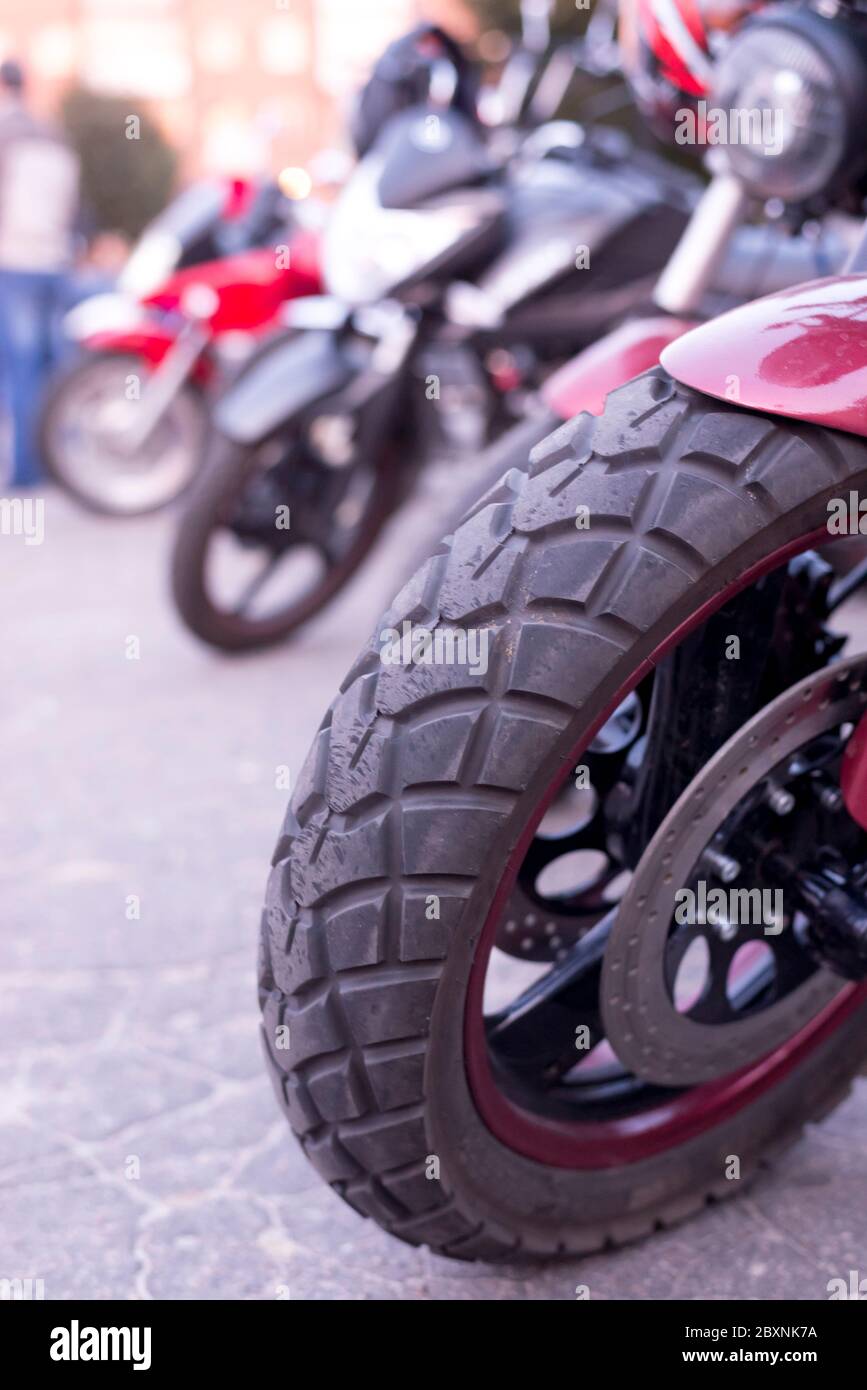 The wheel of a red motorcycle is large on the background of other ...