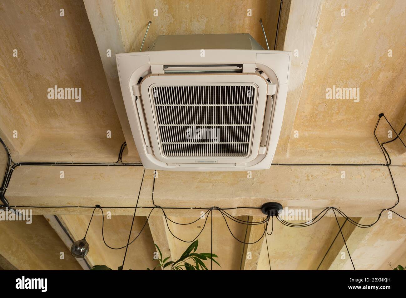 Cassette-type ceiling air conditioning on beige ceiling grunge style ...