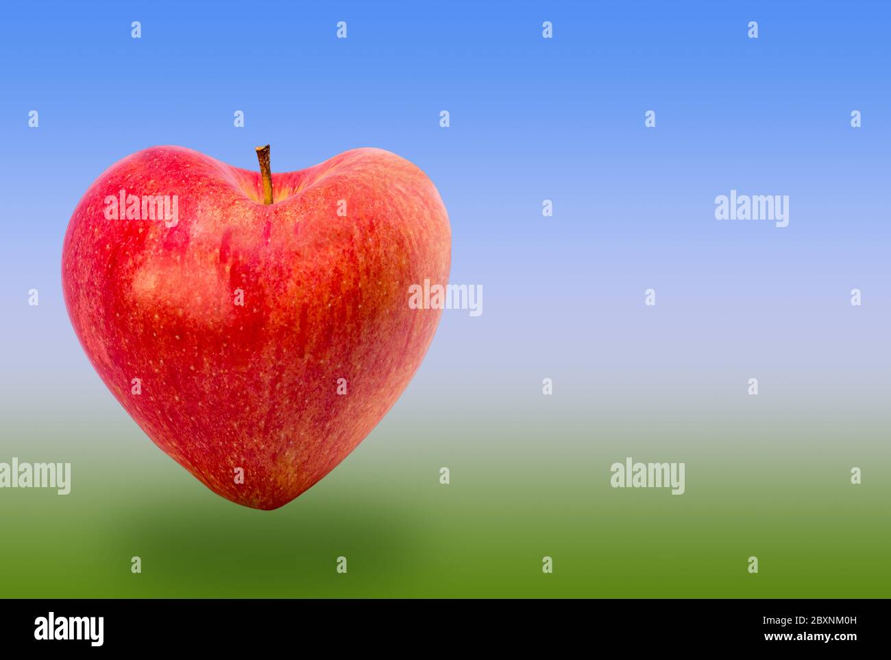 Heart shaped apple on blue sky background, health copyspace Stock Photo ...