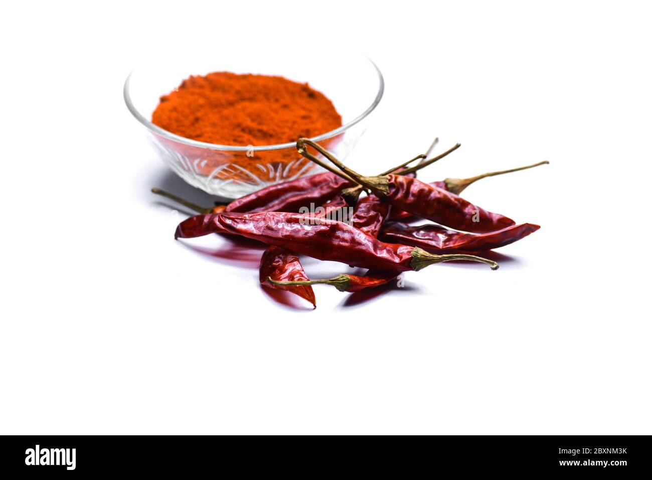 Indian red chilli with powder in a bowl isolated on white background ...
