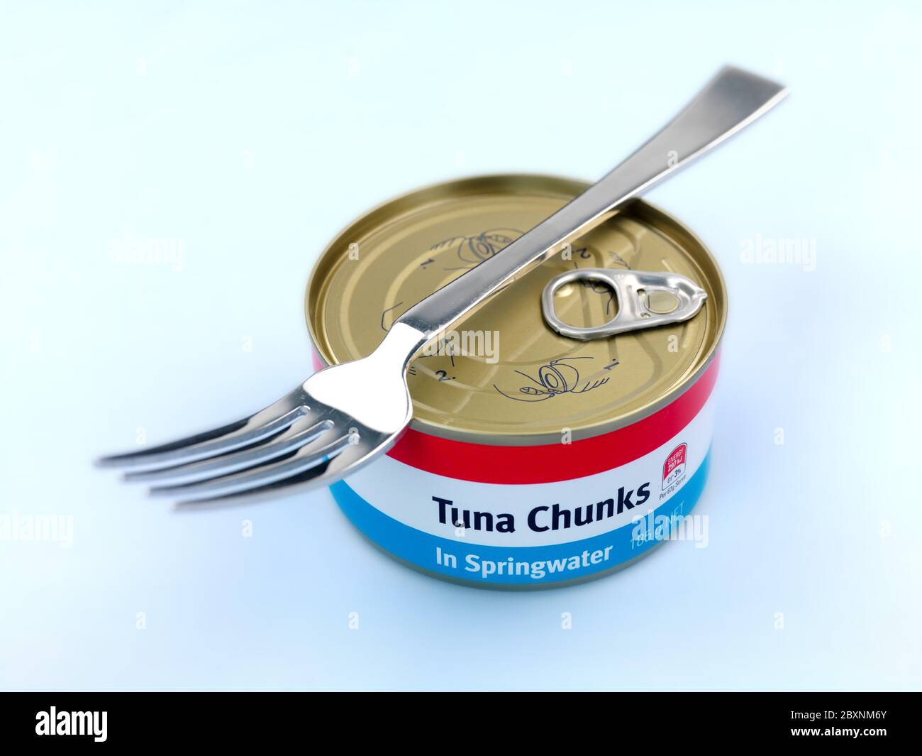 Cans of Tuna isolated against a blue background Stock Photo - Alamy