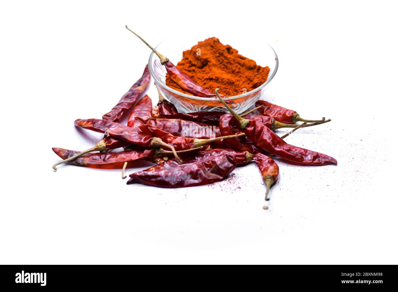 Indian red chilli with powder in a bowl isolated on white background ...