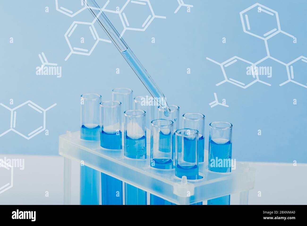 Laboratory glassware with a dropper dripping liquid into a test tube ...