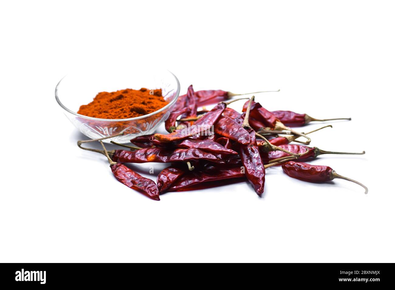 Indian red chilli with powder in a bowl isolated on white background ...