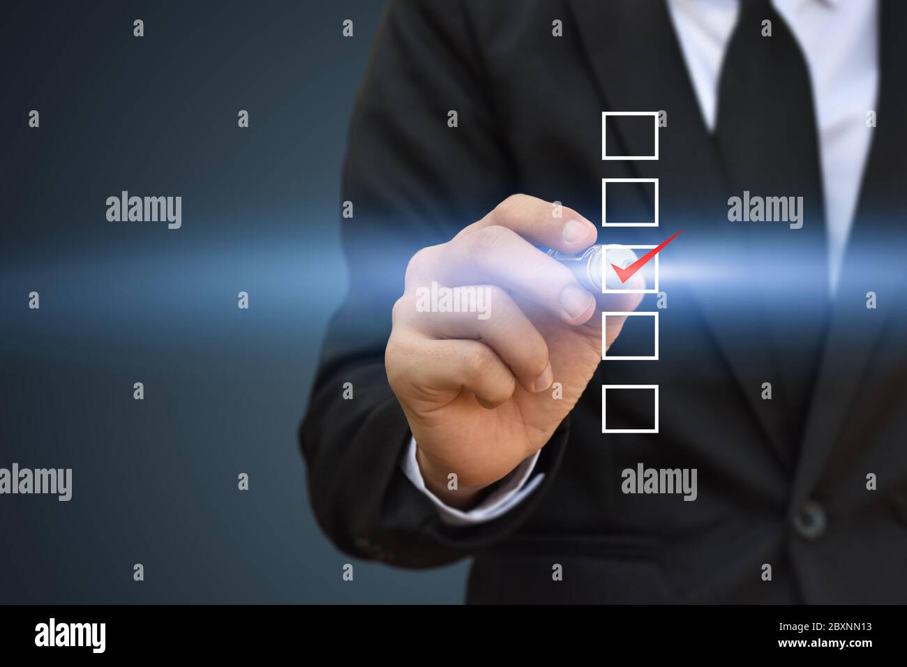 Businessman writing red check mark in a checkbox on blue background ...