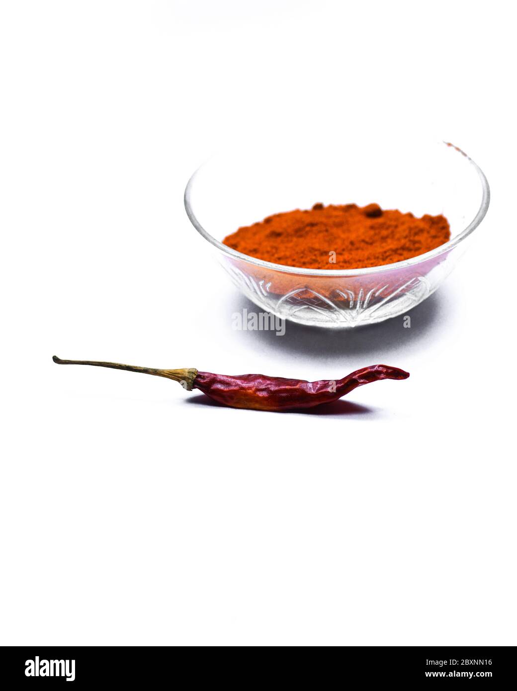 Indian red chilli with powder in a bowl isolated on white background ...