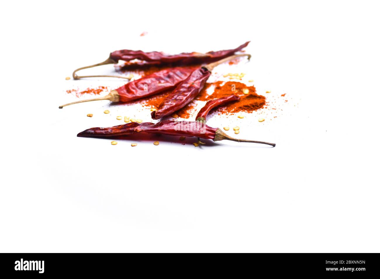 Indian red chilli with powder in a bowl isolated on white background ...