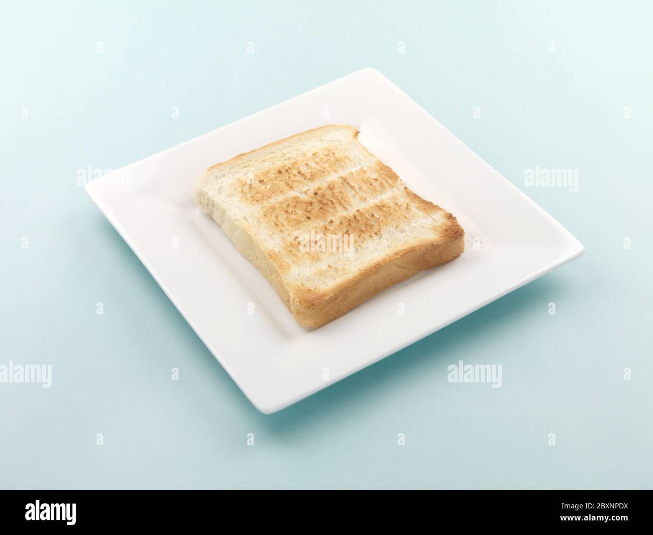Plain white toast isolated against a pale blue background Stock Photo ...
