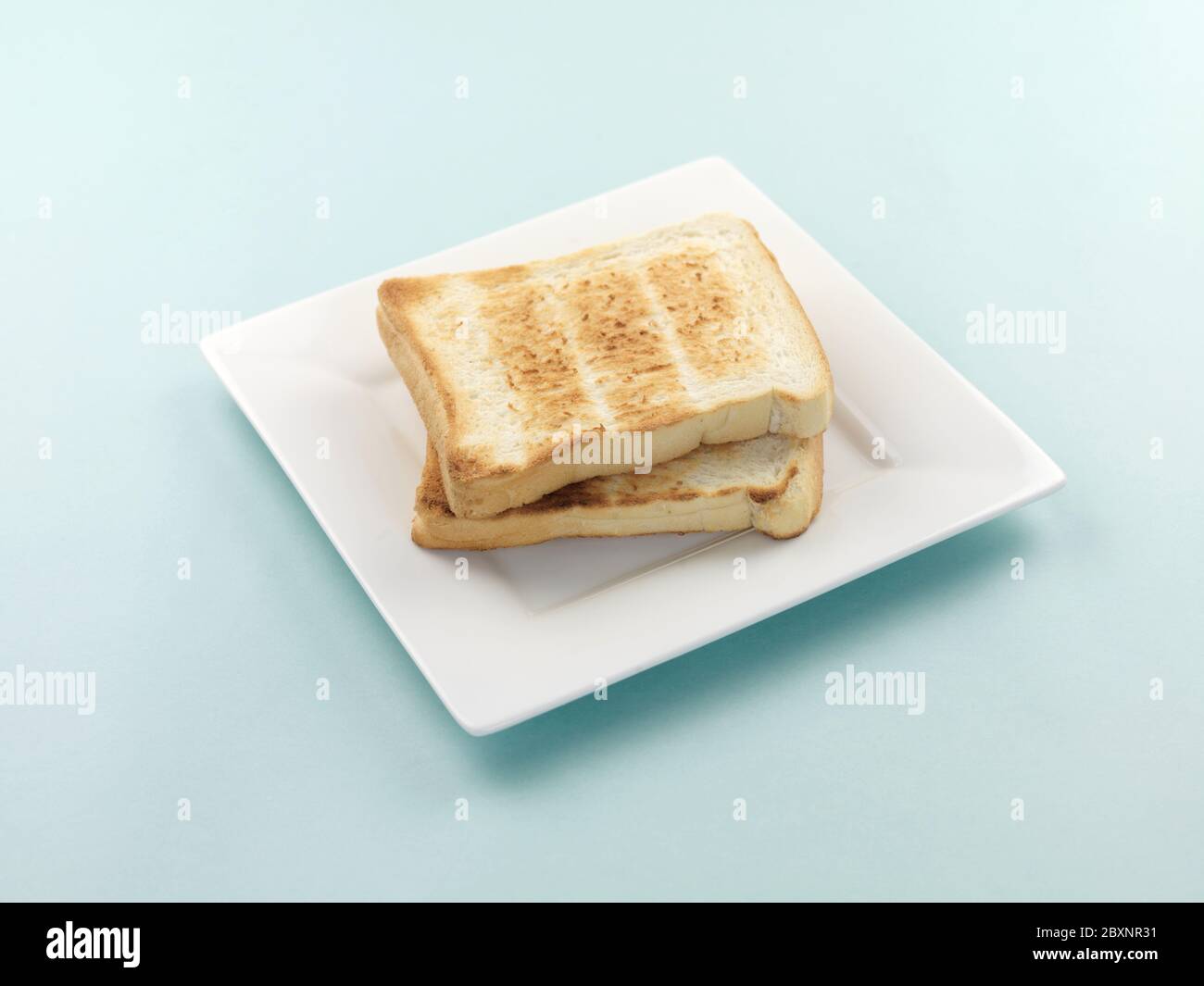 Plain white toast isolated against a pale blue background Stock Photo ...