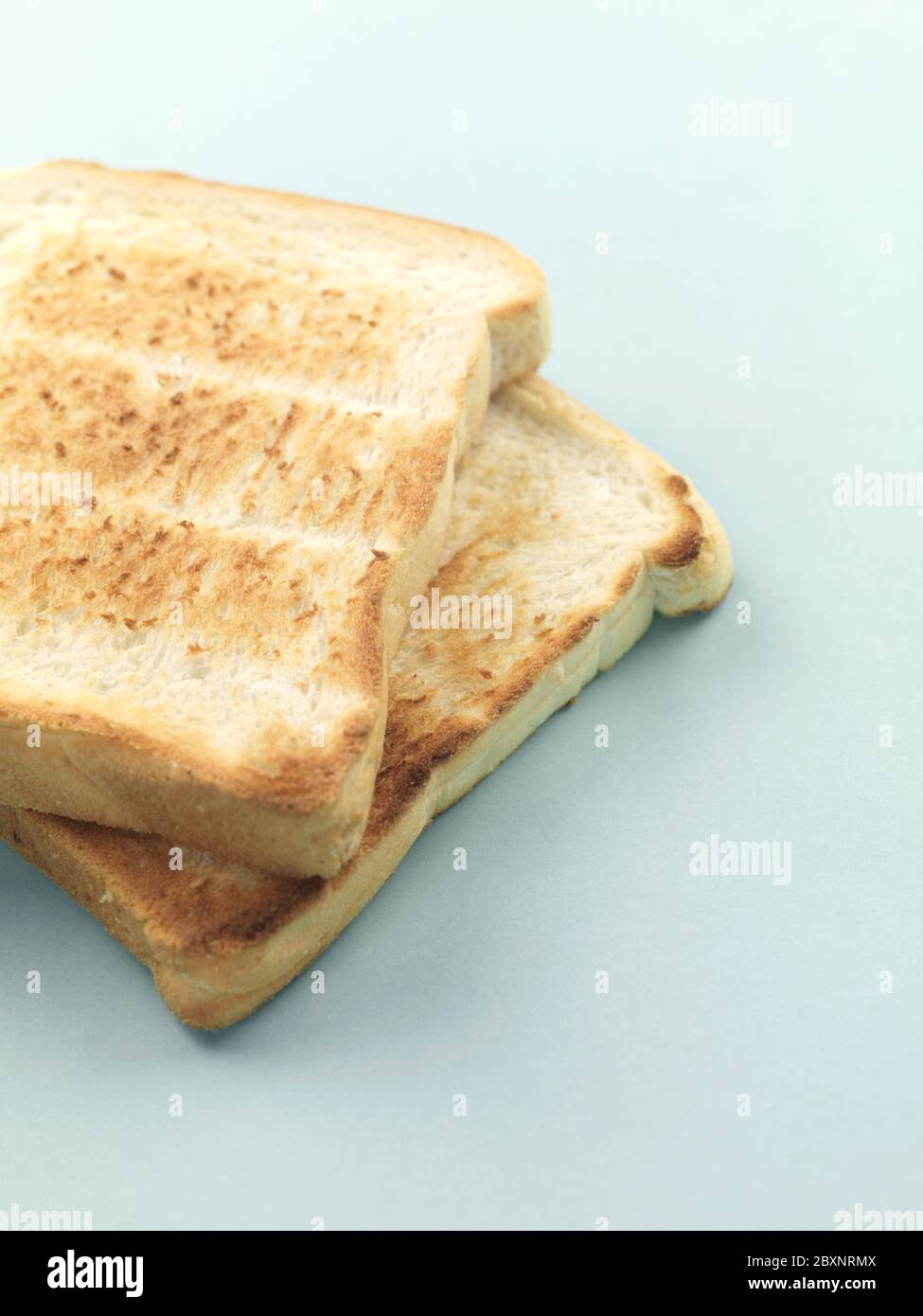 Plain white toast isolated against a pale blue background Stock Photo ...