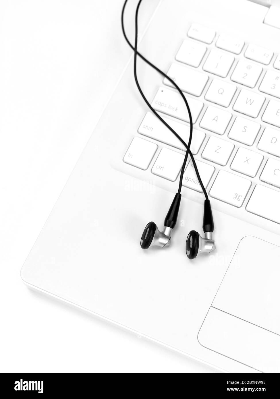 A laptop computer with a set of earphones isolaterd against a white ...