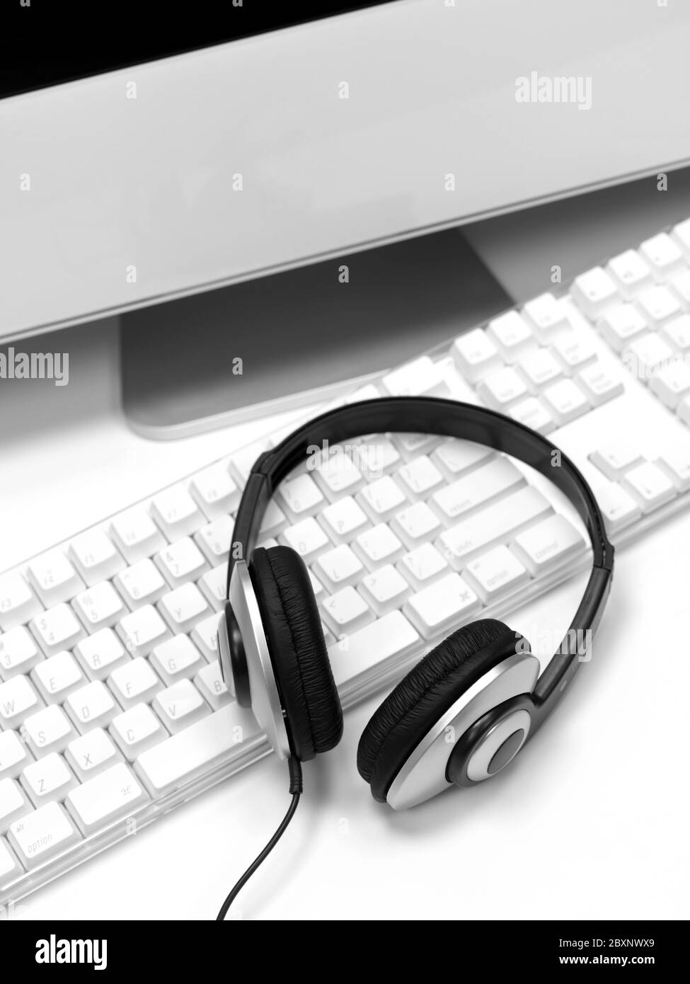 A desktop computer with a set of headphones isolaterd against a white ...