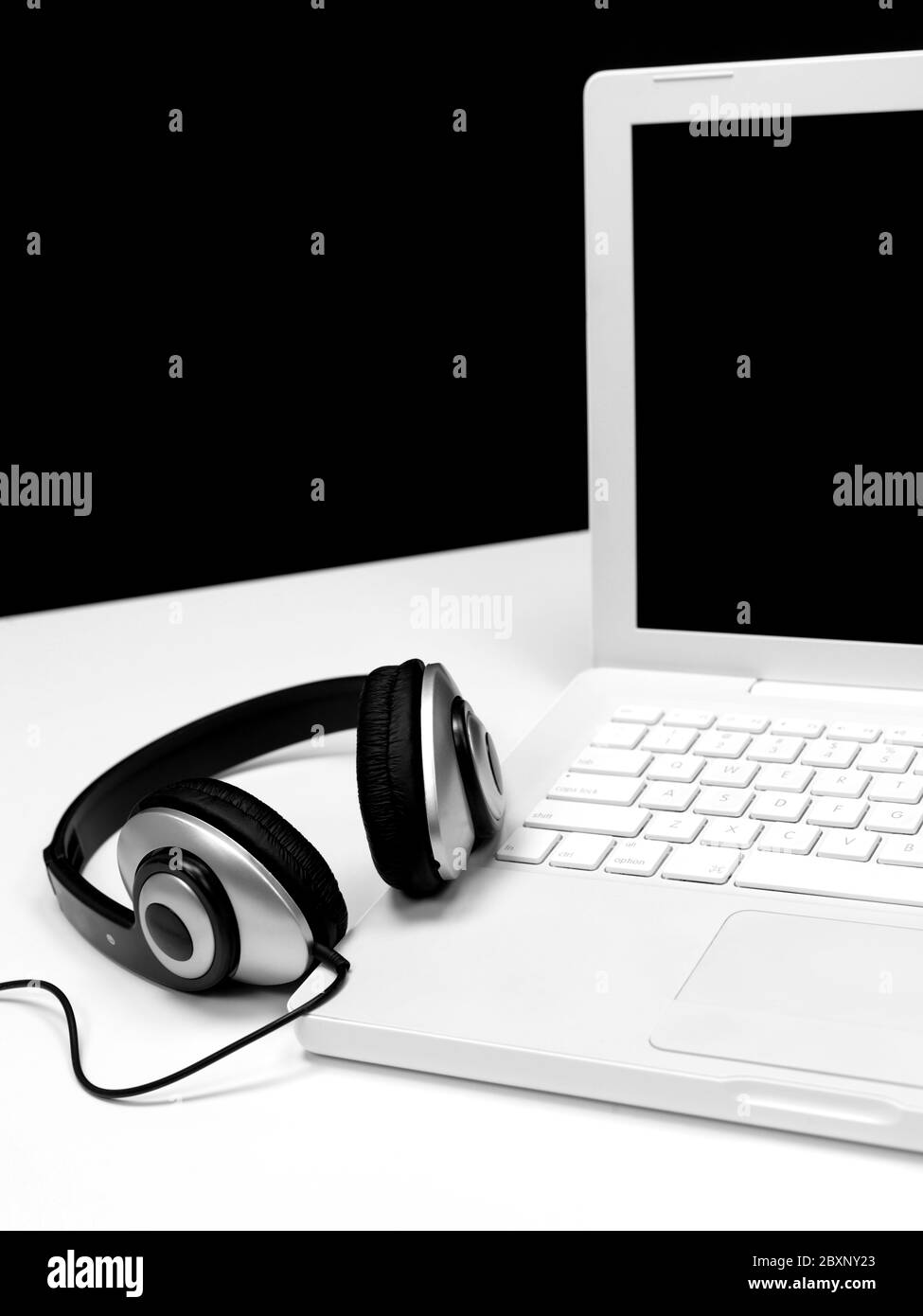 A laptop computer with a set of headphones isolaterd against a white ...