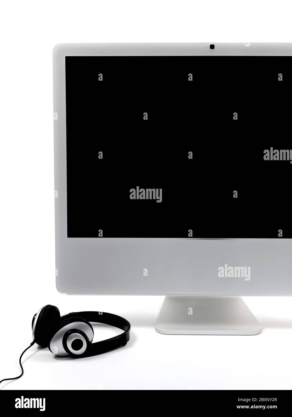A desktop computer with a set of headphones isolaterd against a white ...