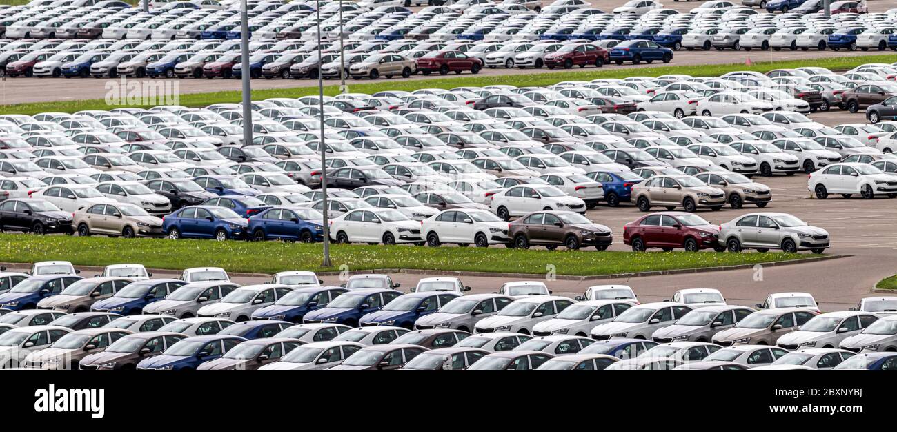 Rows of a new cars parked in a distribution center on a cloudy day in ...