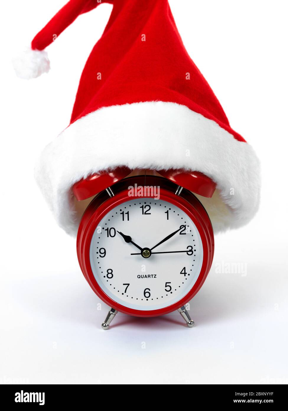 A santa hat and an alarm clock isolated against a white background ...