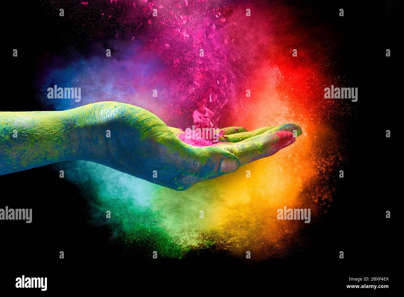 Magical rainbow colored powder exploding from the palm of a cupped hand ...