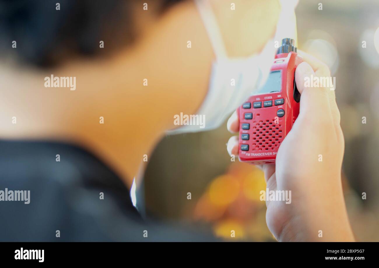 The male hand holding with a red Walkie Talkie or Portable radio ...