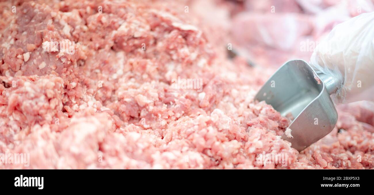 The supermarket employee preparing the Fresh pork meat slice on display ...