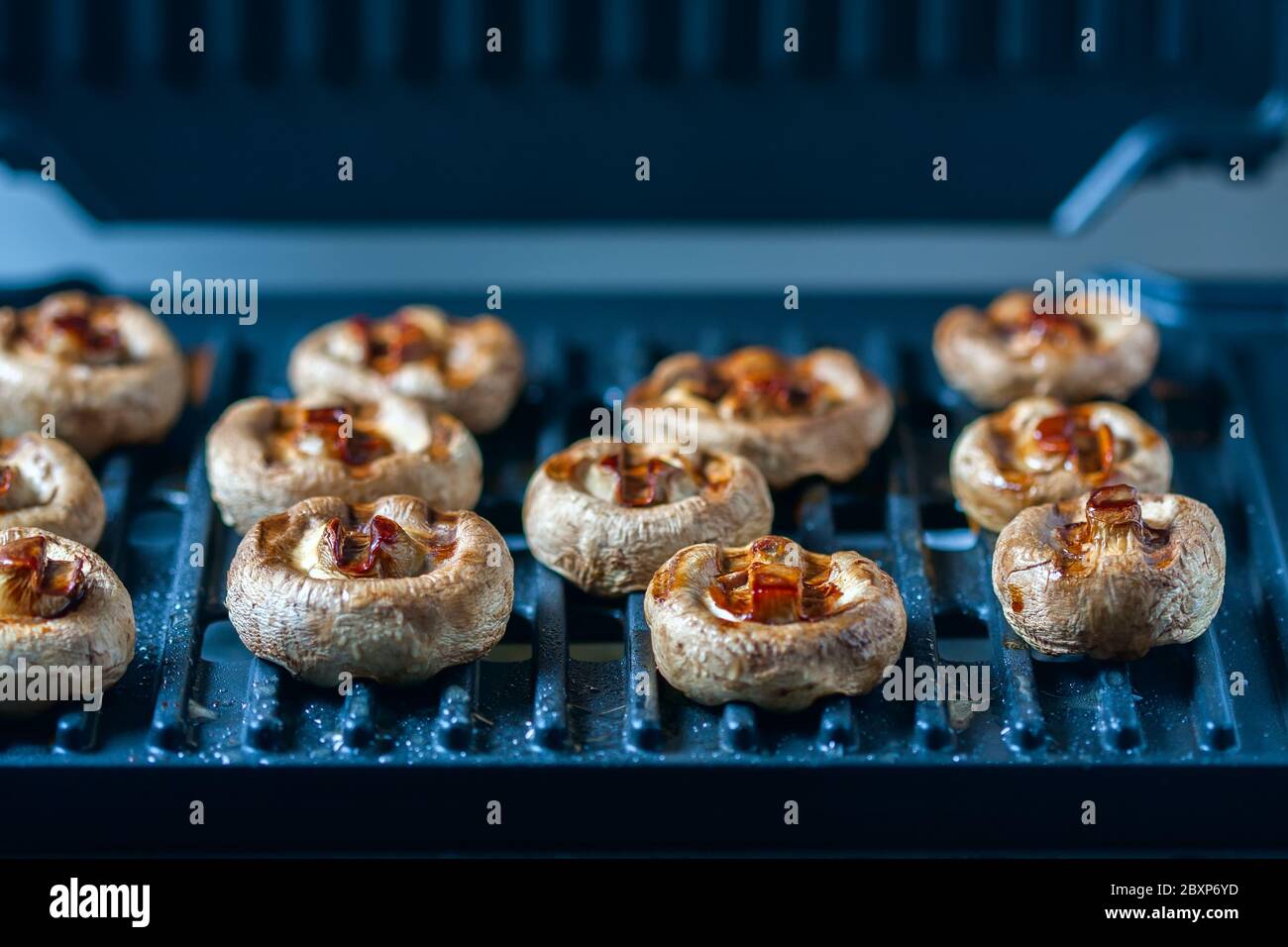 Champignon white mushrooms grilled. Grilled vegetables on a grill close ...