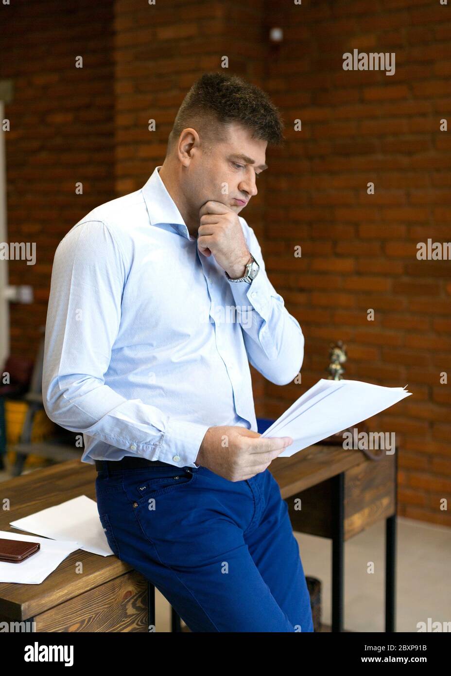 Portrait of a pensive businessman. A man standing checks documents ...