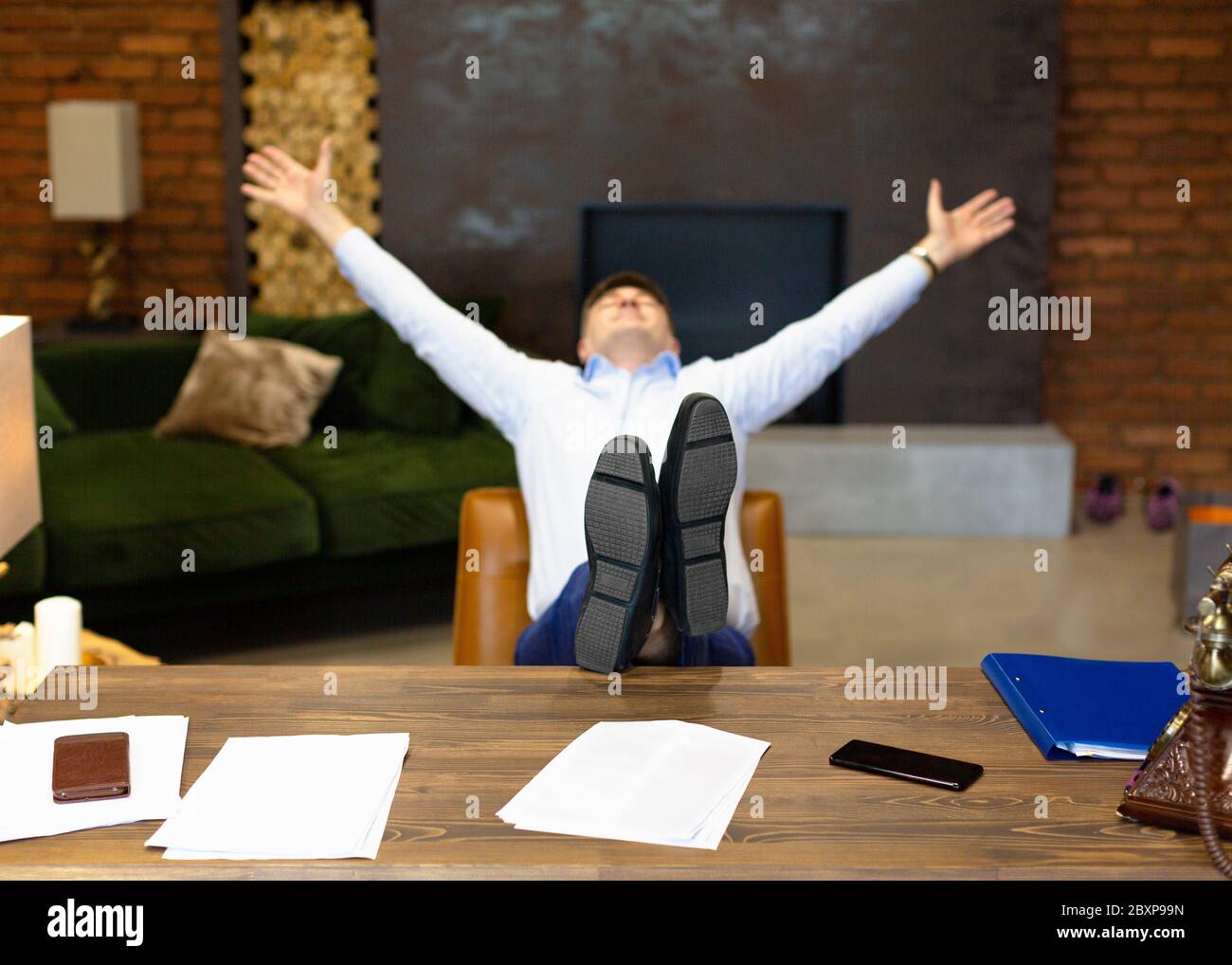 Happy businessman put his feet on the table. Rest after successful ...