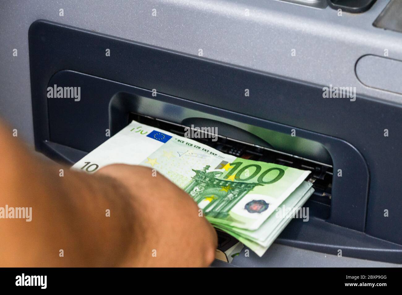 Depositor withdraws EURO from ATM cash money machine. Man hand holding ...