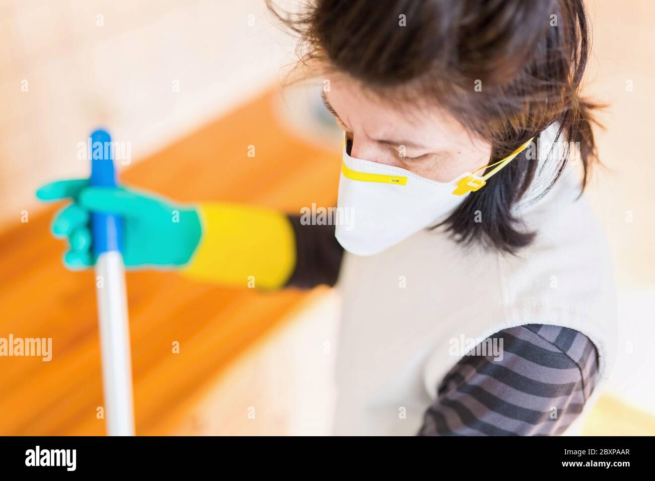 Woman with protective mask and rubber gloves cleaning home Stock Photo ...