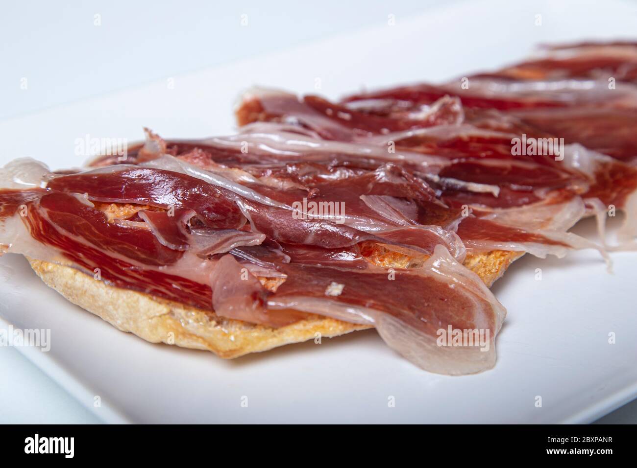 Iberian ham toast. Spanish typical food. Isolated image. Selective ...