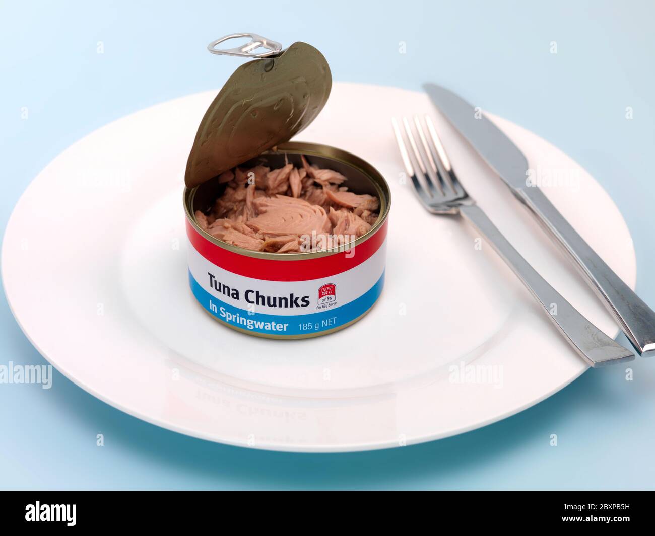 A can of tuna isolated against a blue background Stock Photo - Alamy