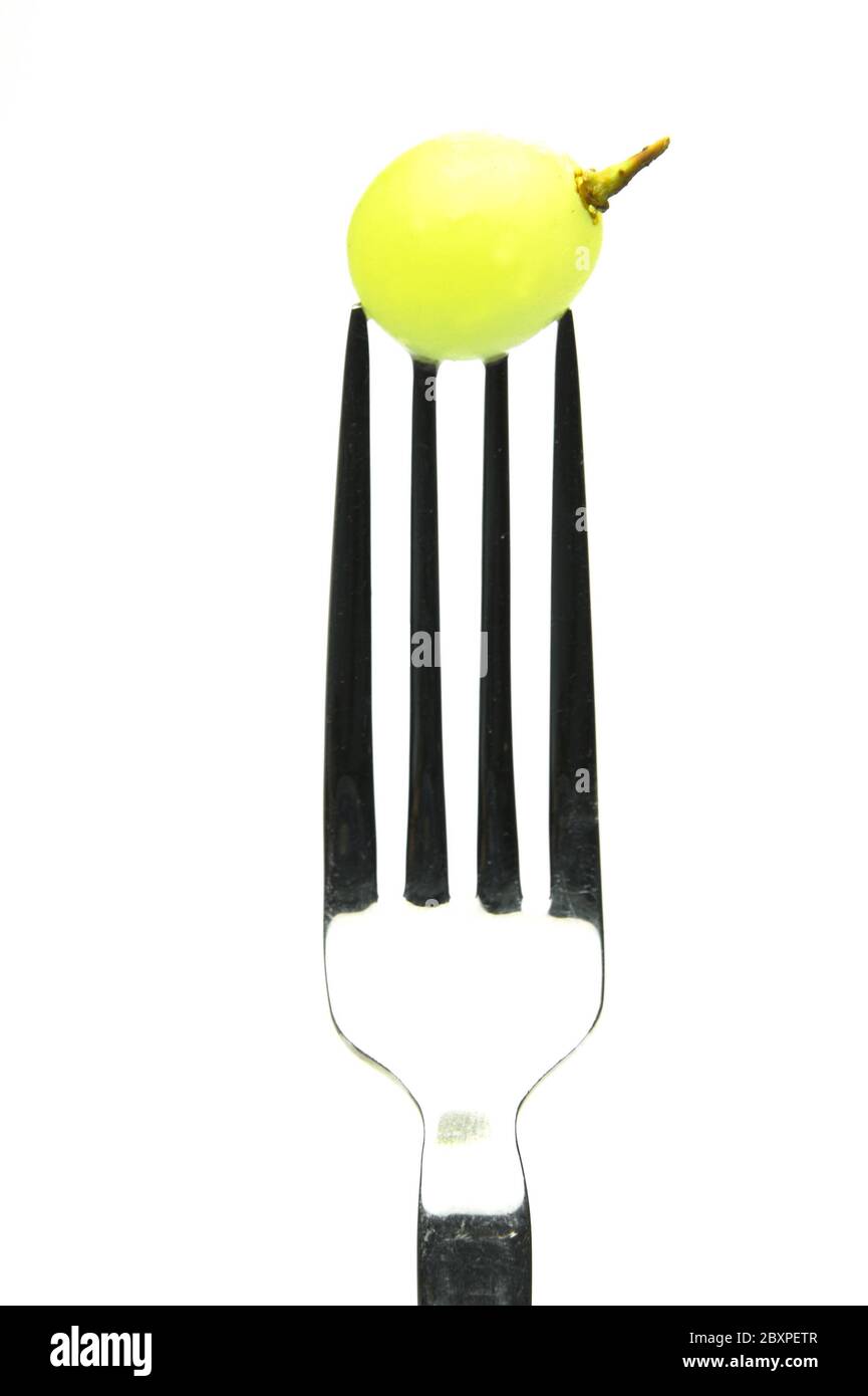 Grape on a fork isolated against a white background Stock Photo - Alamy