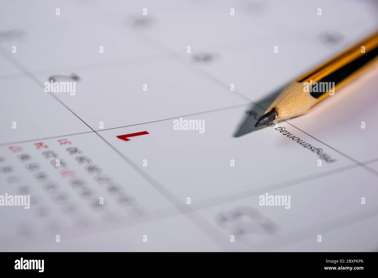 a pencil lies on an open calendar indicating the first day of the month ...