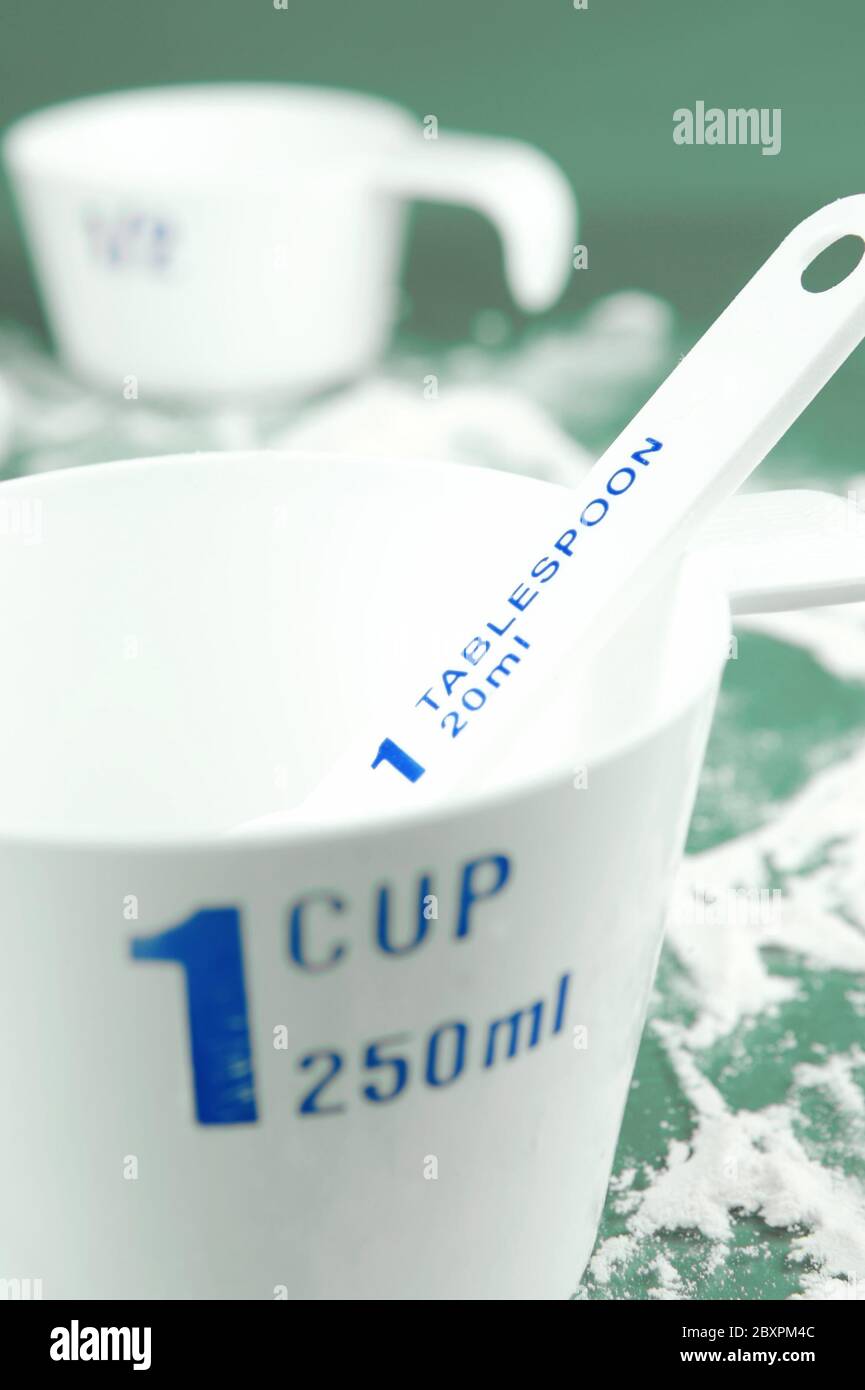 Measuring cups isolated against a green background Stock Photo - Alamy