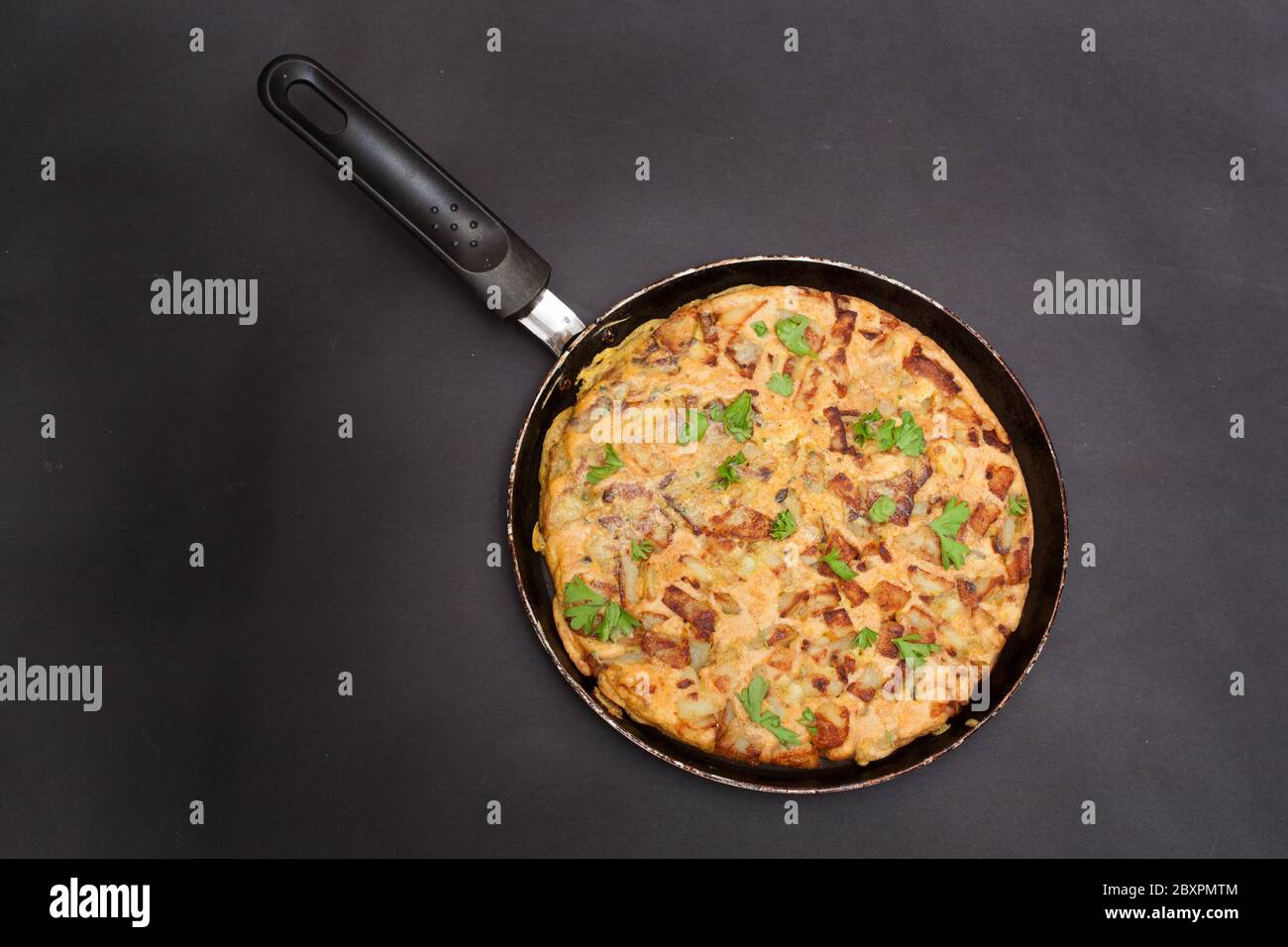 A Libyan potato omelette shot against a black background Stock Photo ...
