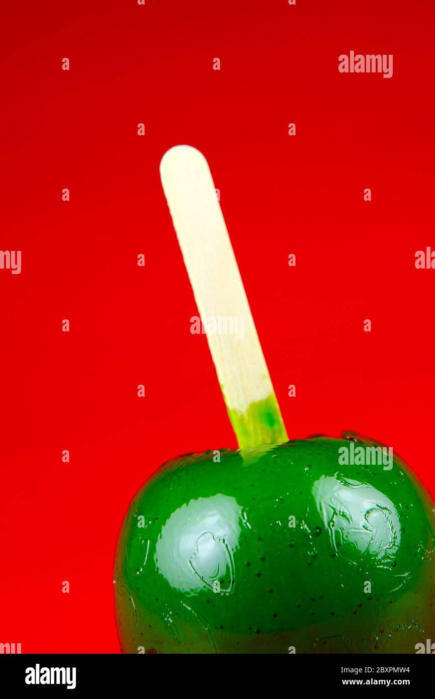 Green Candy apples isolated against a red background Stock Photo - Alamy