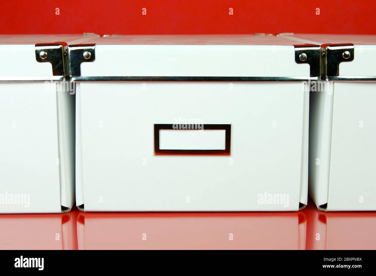 Storage boxes isolated against a red background Stock Photo - Alamy