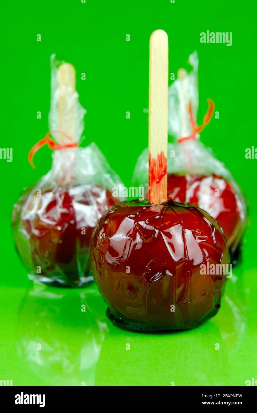 Red Candy apples isolated against a green background Stock Photo - Alamy