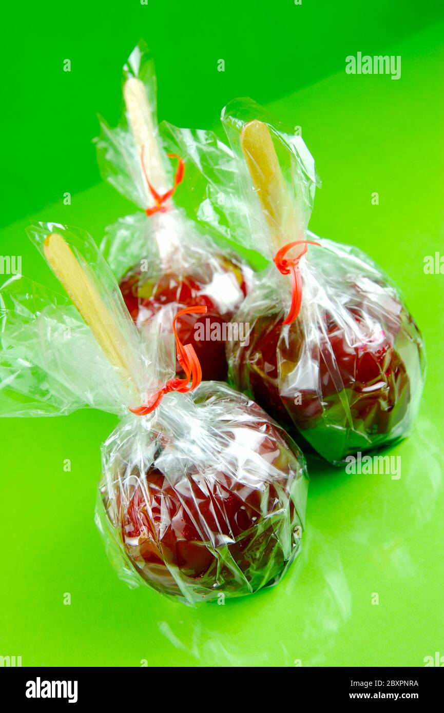 Red Candy apples isolated against a green background Stock Photo - Alamy