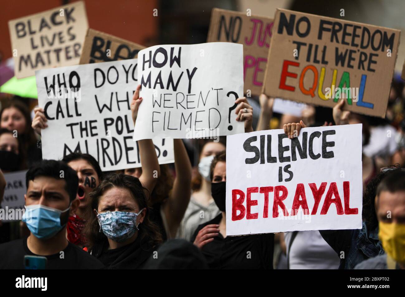 Protesters in a medical masks hold placards with slogans condemning ...