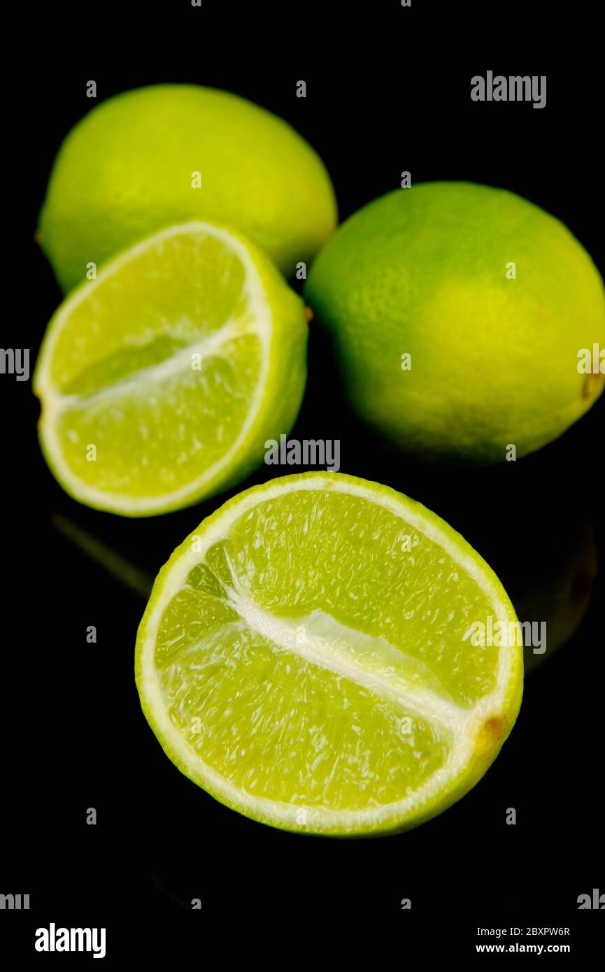 Lime fruits isolated against a black background Stock Photo - Alamy