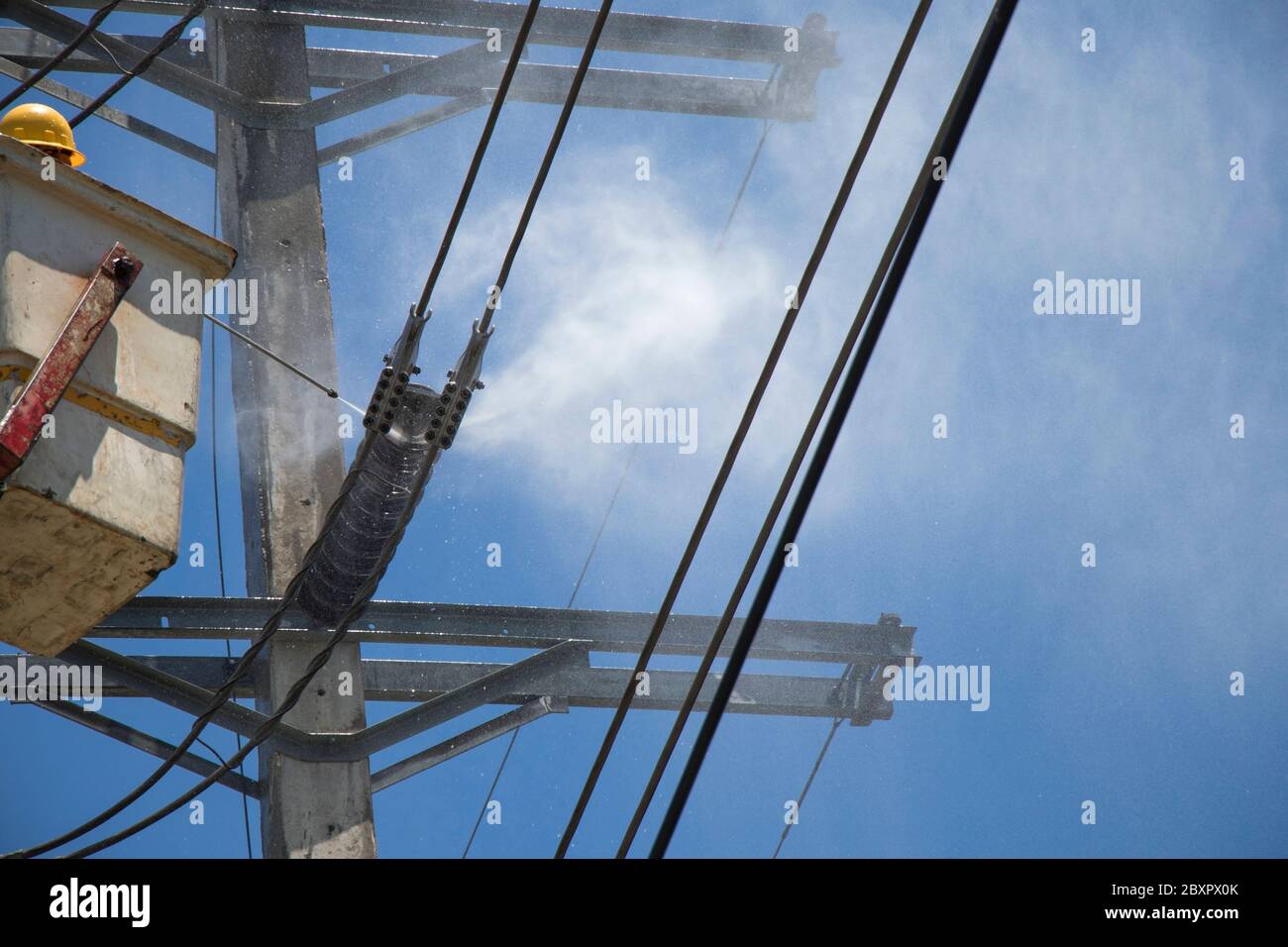 Electricity authority clean the ceramic insulator on the electric pole ...
