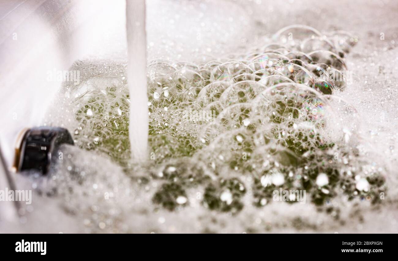 Water from the tap flows into the bathroom. The flow of water is close ...