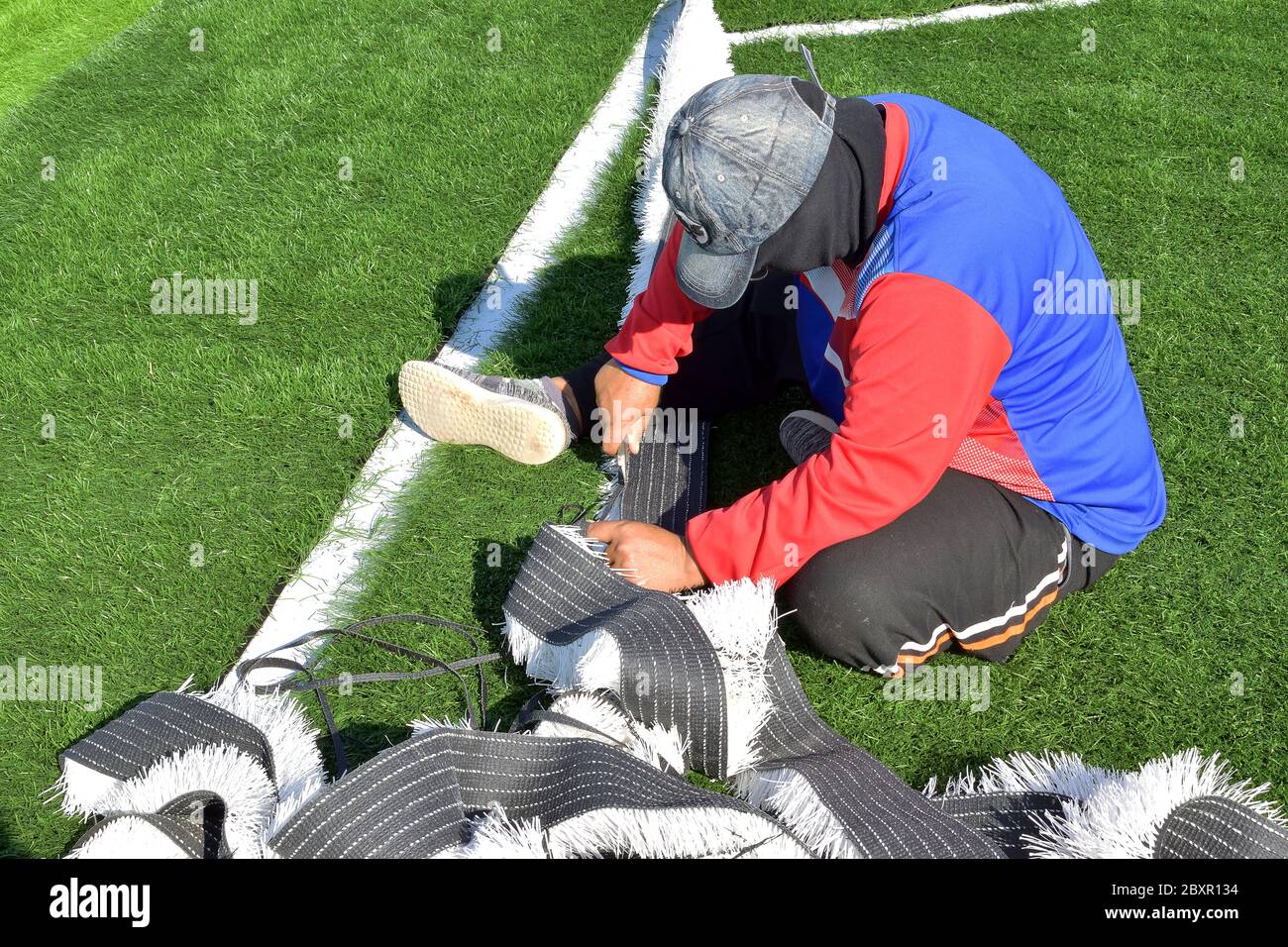 Football field installation of artificial grass by technicians Stock ...