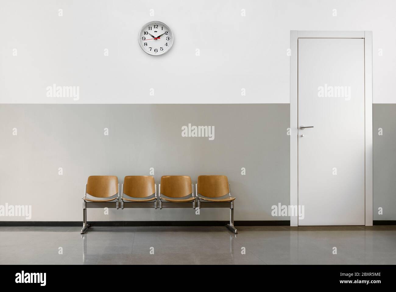 empty waiting room with chairs, clock on wall and door Stock Photo - Alamy