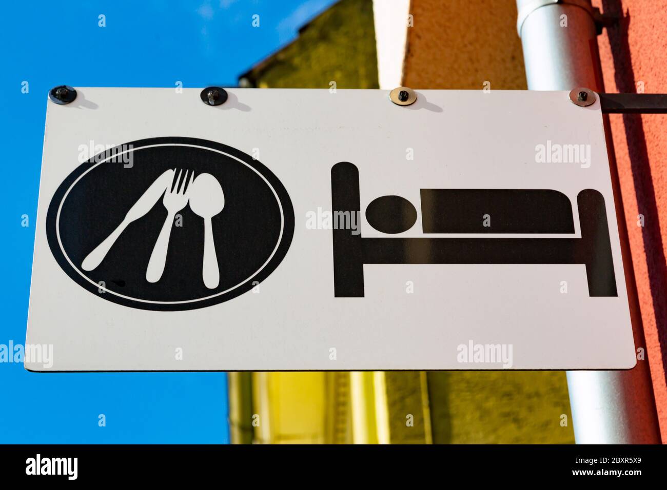 Sign for sleeping accommodation and restaurant on a pole outside a ...