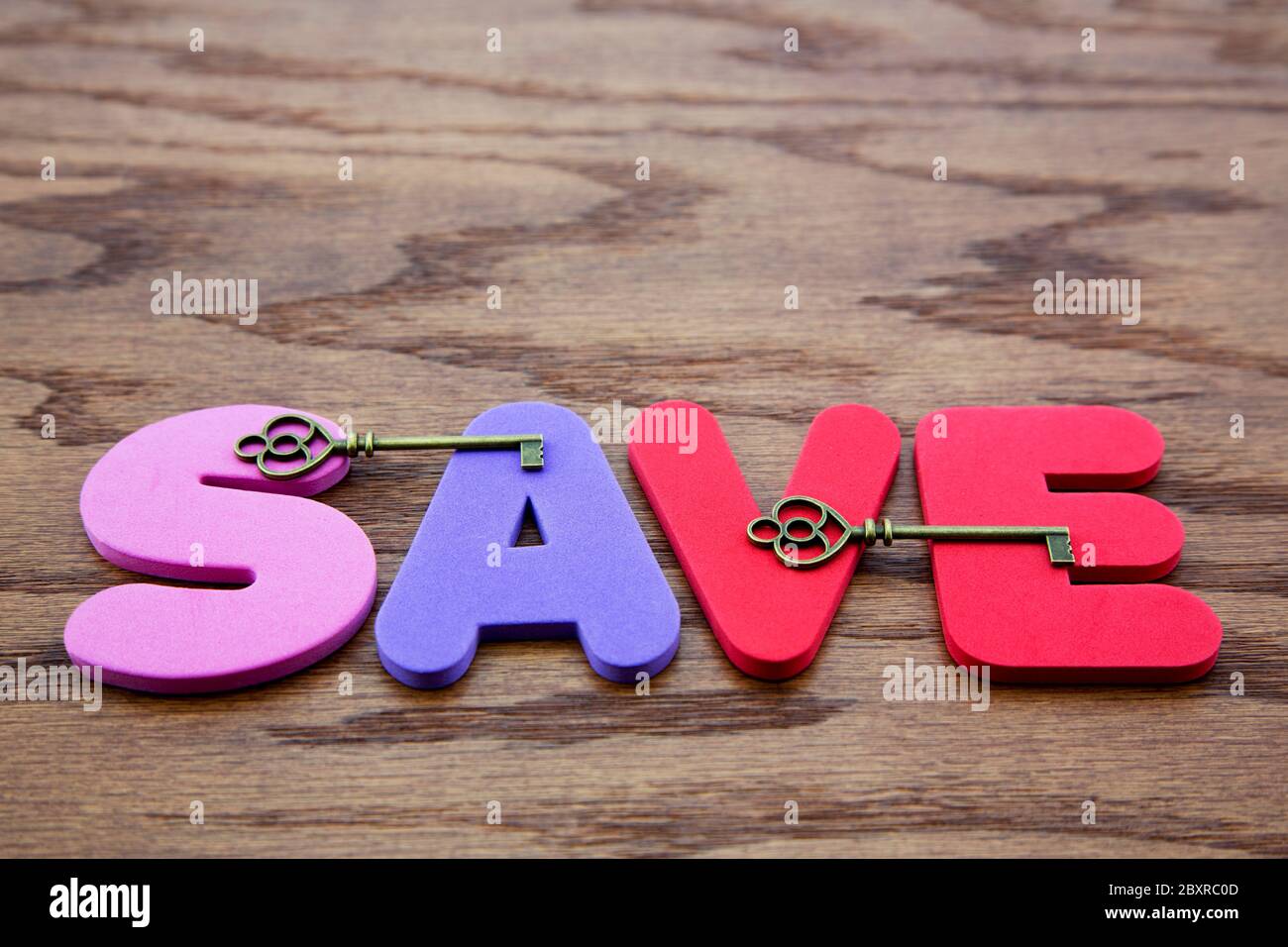 Brass keys placed with letters spelling SAVE reflect saving and ...