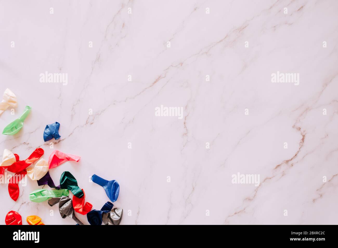Flat lay of deflated water ballons against a marble background with ...