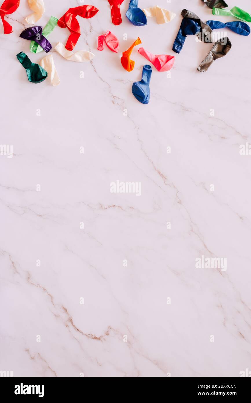 Flat lay of deflated water ballons against a marble background with ...