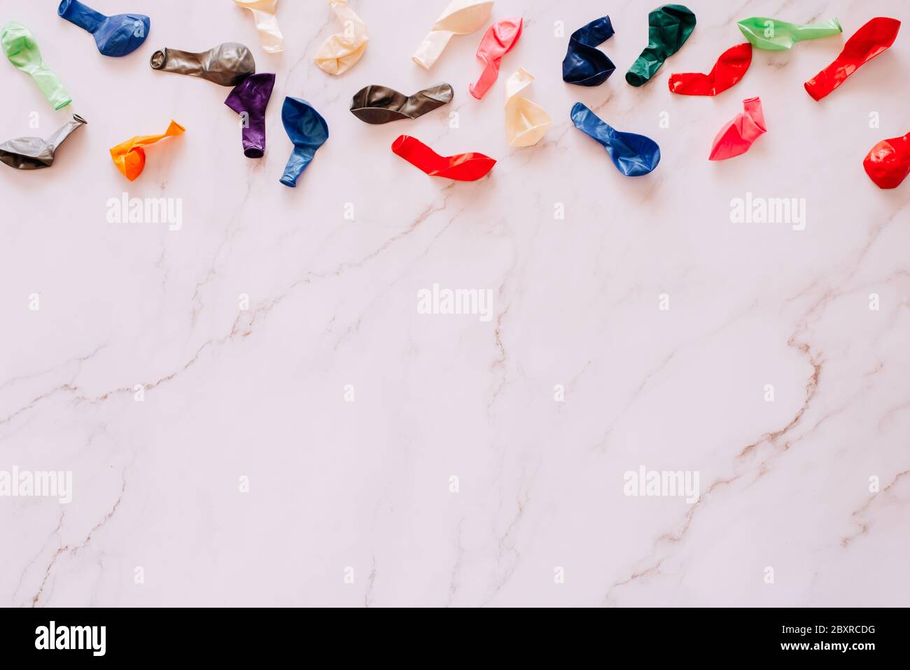 Flat lay of deflated water ballons against a marble background with ...